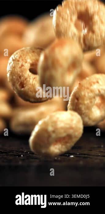 Corn flakes falling on black background. Filmed on a high-speed camera ...