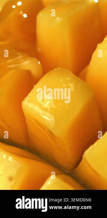 The juice flows through the sliced mango fruit. Filmed on a high-speed ...
