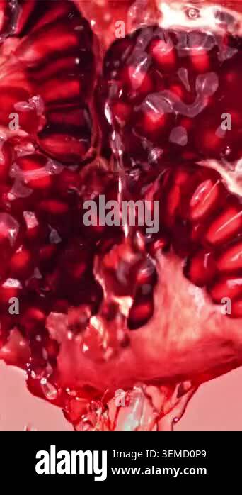 Fresh juice runs down the pomegranate. Filmed on a high-speed camera at ...