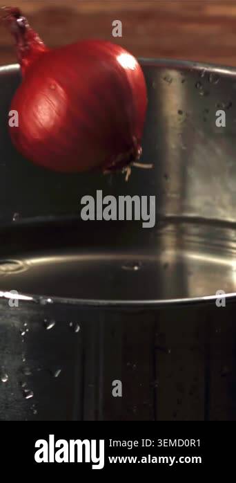 Onion falls in pan with water. Filmed is slow motion 1000 fps. High ...