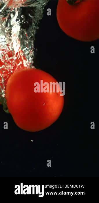 Tomatoes fall under water. Filmed is slow motion 1000 fps. High quality ...