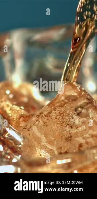 Cola is poured into a glass with ice. Filmed is slow motion 1000 fps ...