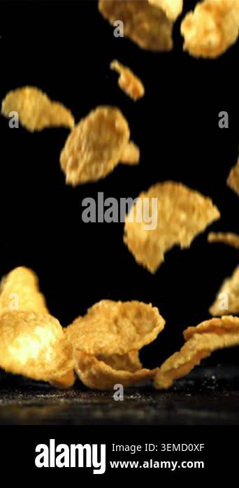 Corn flakes falling on black background. Filmed on a high-speed camera ...