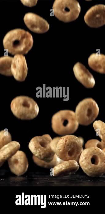 Corn flakes falling on black background. Filmed on a high-speed camera ...