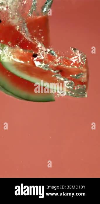 Watermelon slices fall under the water. Filmed on a high-speed camera ...