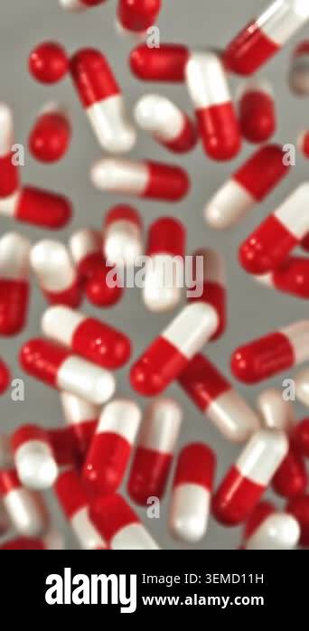 Pale grey background tumbling red white capsules in laboratory Filmed ...