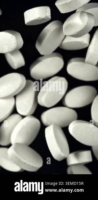White tablets tumbling across black background, monochrome tablet ...