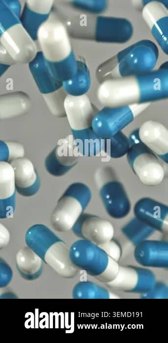 Floating blue and white capsules on gray background, closeup macro ...