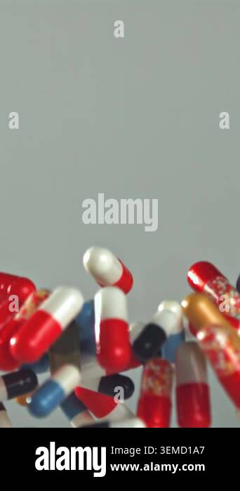 Multicolored capsules exploding into light background. Lively studio ...
