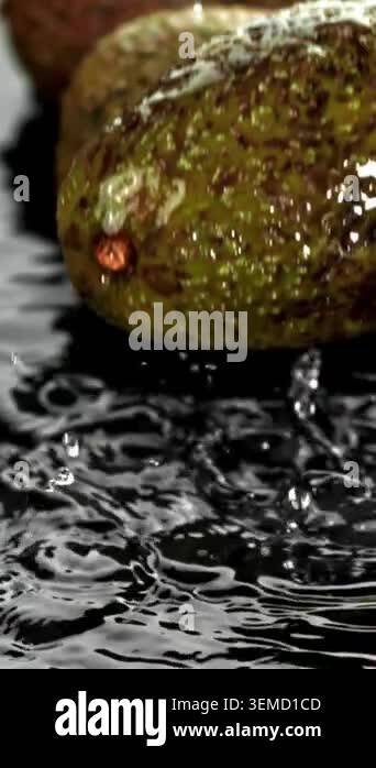 Super slow motion fresh avocado with splashes and drops. Filmed on a ...