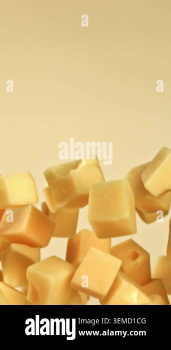 Cubes of maasdam cheese fly on a light background. Filmed on a high ...
