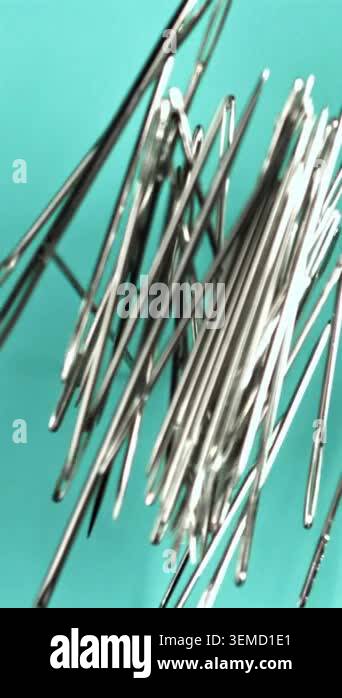 Sewing needles fall on the table. Filmed on a high-speed camera at 1000 ...