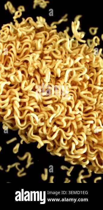 Instant noodles fly and fall on a black background. Filmed on a high ...