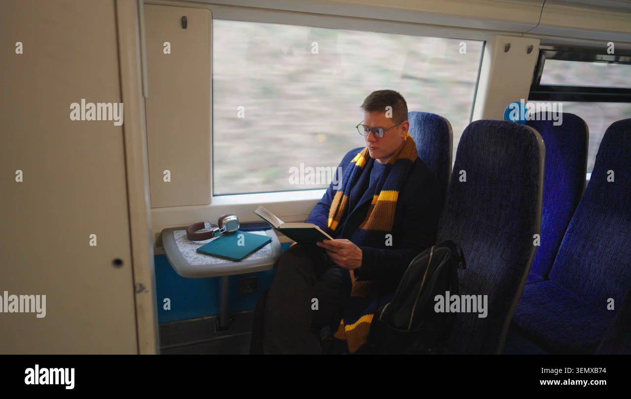 Man reading book on train journey Stock Video Footage - Alamy