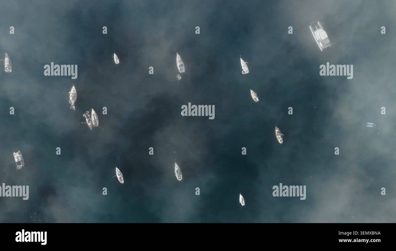 Boats anchored in the sea under morning fog, top down aerial shot Stock ...