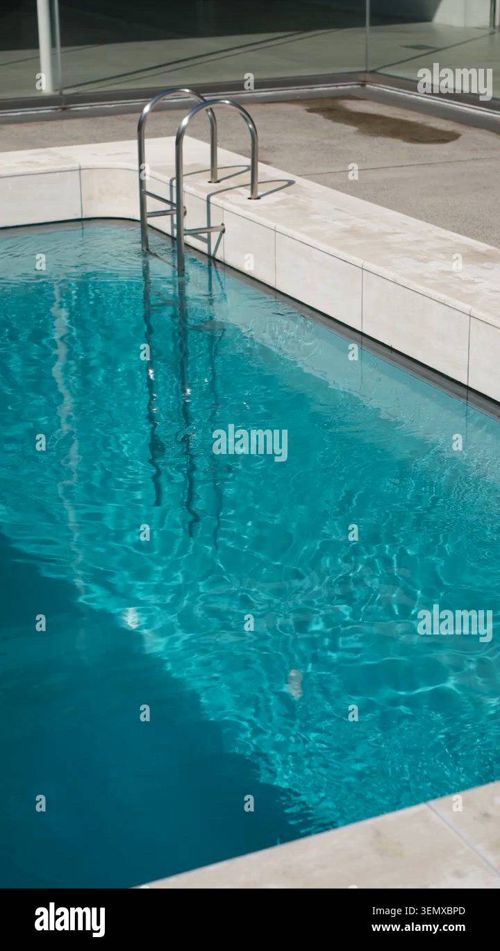 Sunlit Swimming Pool with Turquoise Water and Chrome Ladder Entry Stock ...