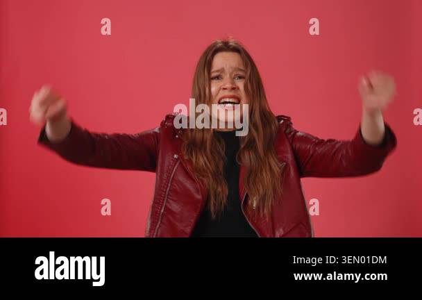 A woman in a red leather jacket with long hair is expressing strong ...