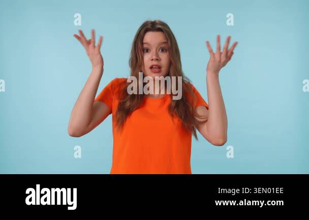 A young woman wearing an orange shirt shows a confused expression ...