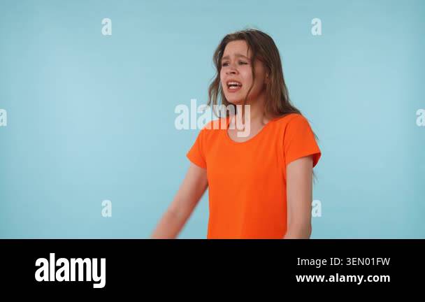 A woman in a bright orange shirt shows vivid emotions with an open ...