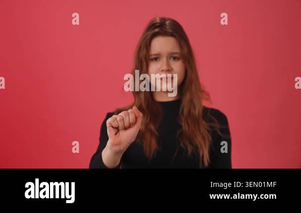 A woman holds up her hand with the word STOP written on it, set against ...