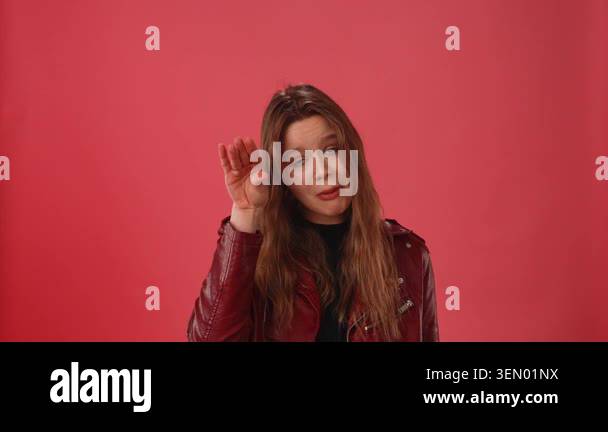A person wearing a red jacket makes a humorous facial expression using ...