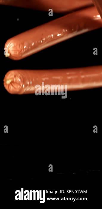 Super slow motion sausages with water splashes . Filmed on a high-speed ...