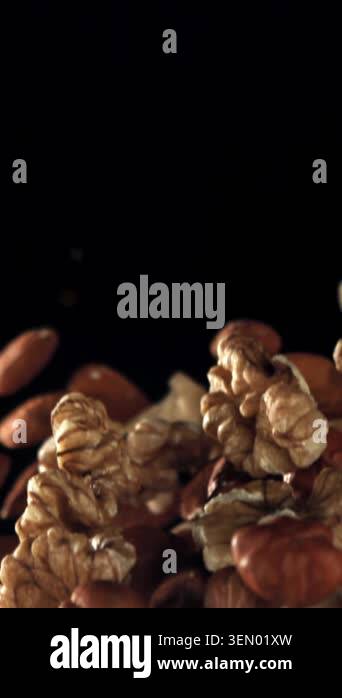 Different types of nuts fly up and fall down. Filmed on a high-speed ...