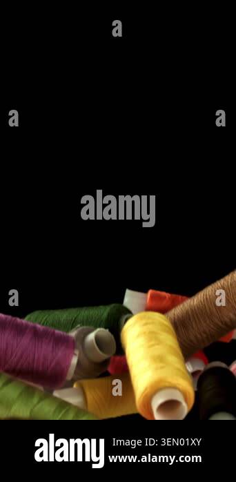 Multi-colored threads fly on a black background. Filmed on a high-speed ...