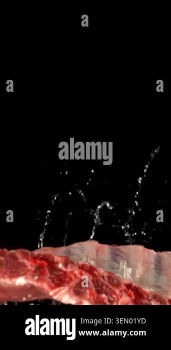 Raw ribs rise and fall on a black background. Filmed on a high-speed ...