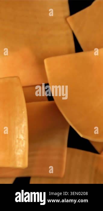 Sliced cheddar cheese flies on a black background. Filmed on a high ...