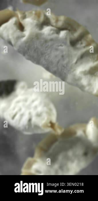 Asian gyoze dumplings fly up and fall down. Filmed on a high-speed ...