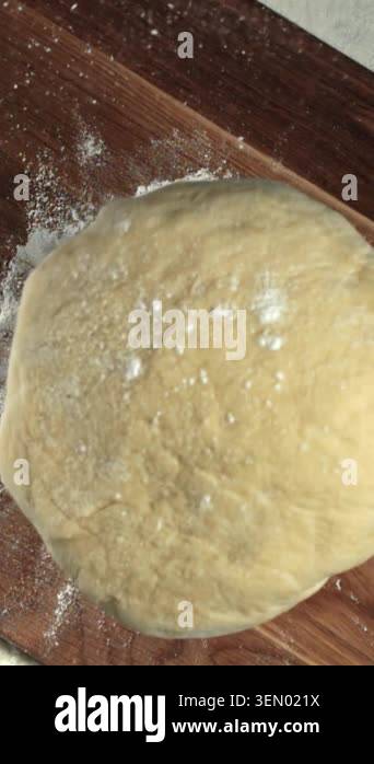Fresh dough falls on cutting board. View from above. Filmed on a high ...