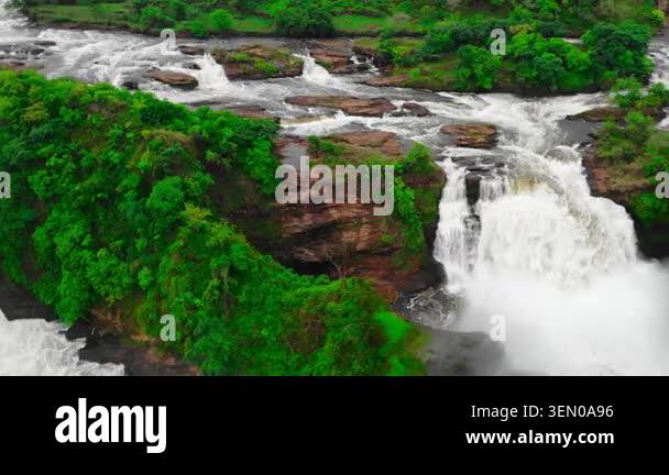 Aerial Tropical Waterfall Surrounded By Dense Rainforest And Rugged ...