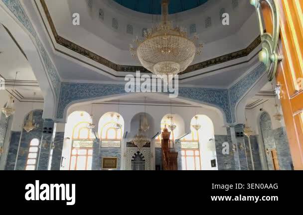 Ornate mosque interior with chandelier, domed ceiling, arched windows ...