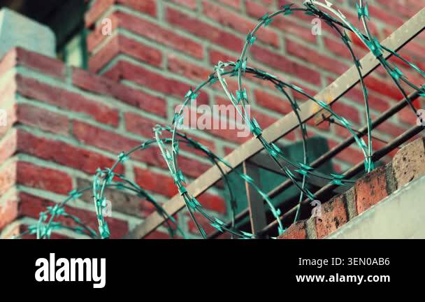 Close up of twisted razor wire with selective focus against a textured ...