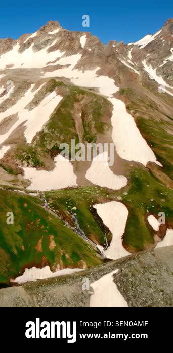 Alpine Mountain Valley With Snow Patches, Sunlit Ridges And Green ...