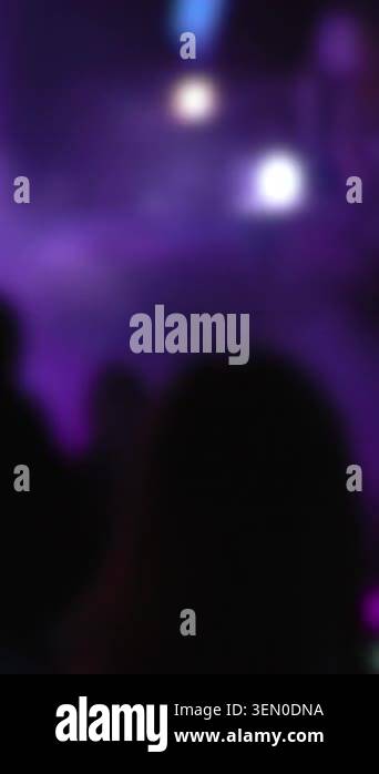 Dimly Lit Concert Crowd Under Purple Haze, Silhouetted Figures Pulsing ...