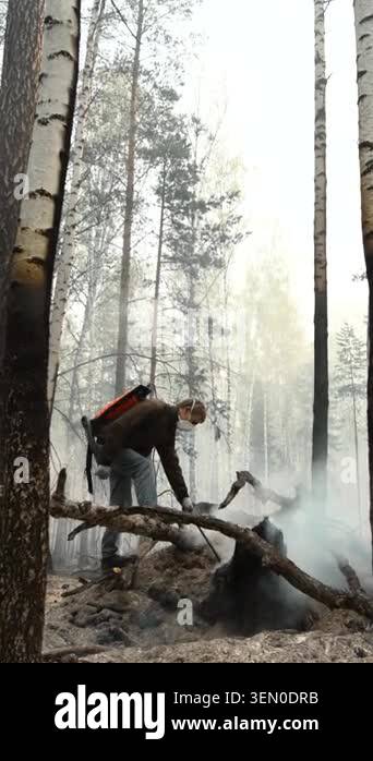 Masked White Responder Monitors Smoldering Log, Clears Ash And Checks ...