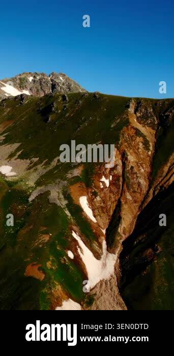 Alpine Mountain Valley With Snow Patches, Sunlit Ridges And Green ...