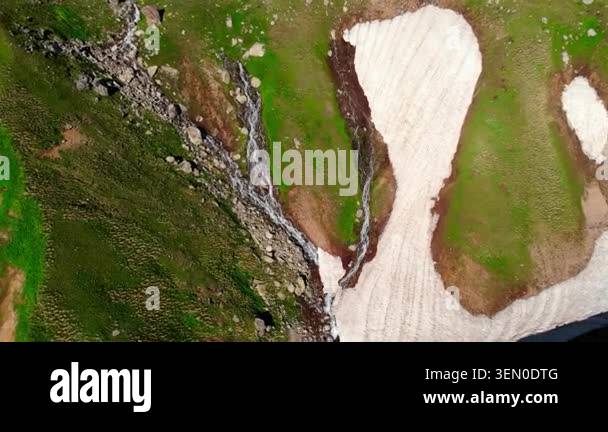Overhead view of a rocky stream winding through rugged hillsides and ...