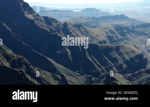 Wide aerial view of rugged rocky mountain ridges overlooking a vast dry ...
