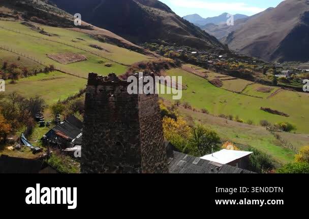 Wide aerial view of an old stone tower ruin overlooking a rural ...