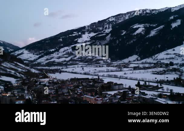 Wide winter landscape with a snow-covered mountain, a small village ...