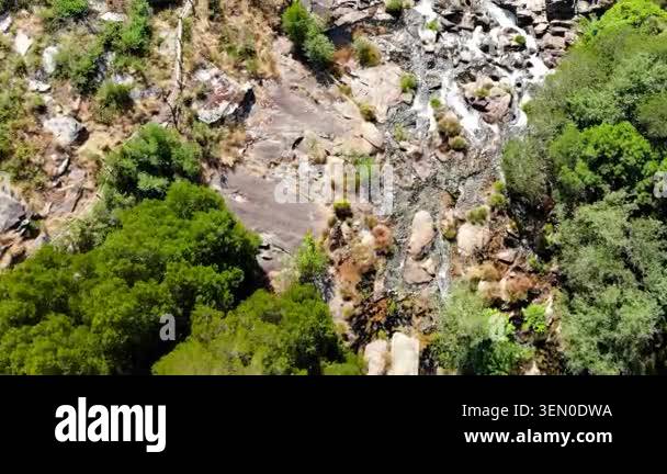 Overhead view of a rocky stream winding through rugged hillsides and ...