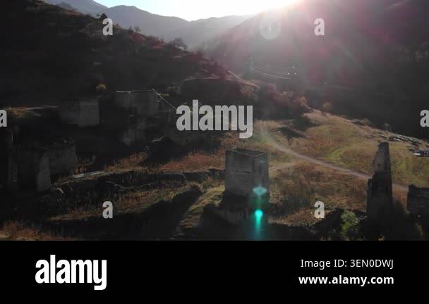 Wide scenic view of a remote mountain valley with a dusty winding road ...