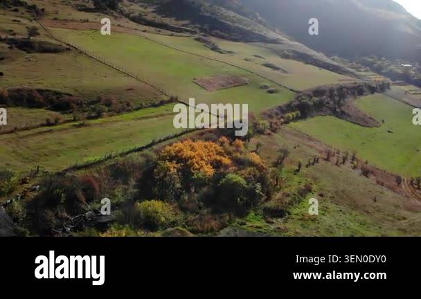 Wide aerial view of a peaceful rural valley with patchwork green fields ...