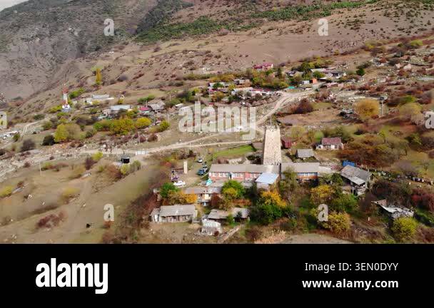 Wide aerial view of a remote hillside village with scattered houses ...