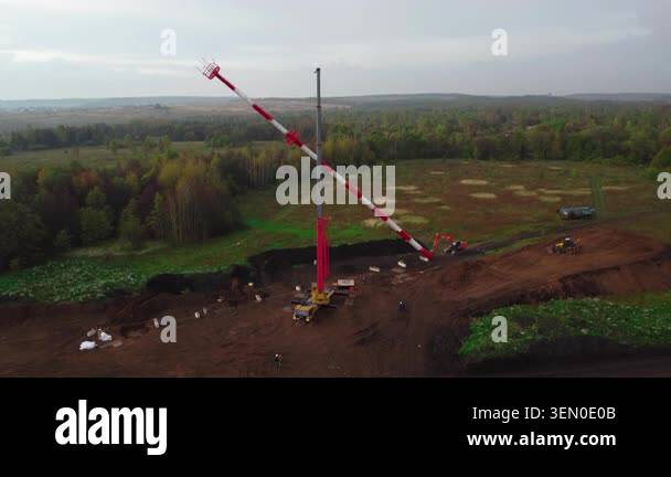 Aerial view of a large rural construction site with a tall crane boom ...