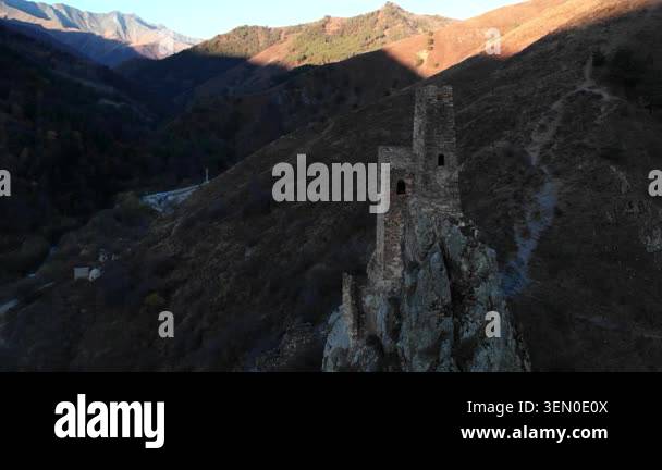 Aerial view of an ancient stone tower ruin standing on a rocky mountain ...