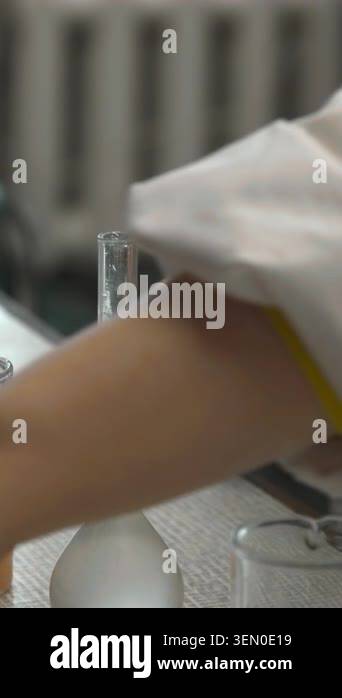 Hands Dispensing Clear Liquid Into Glass Flask On Lab Bench Using ...